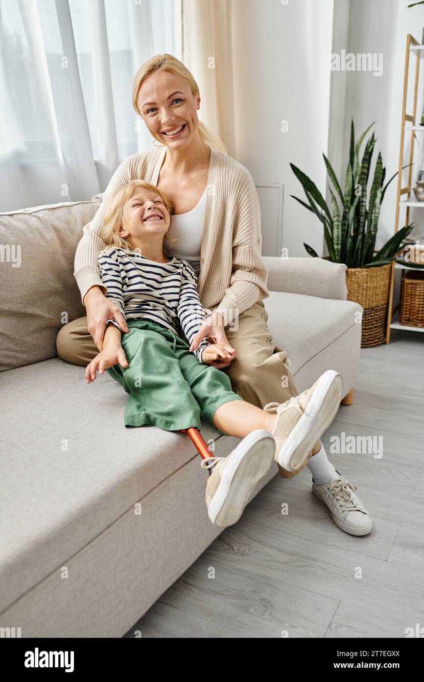 happy mother hugging cute daughter with prosthetic leg and sitting ...