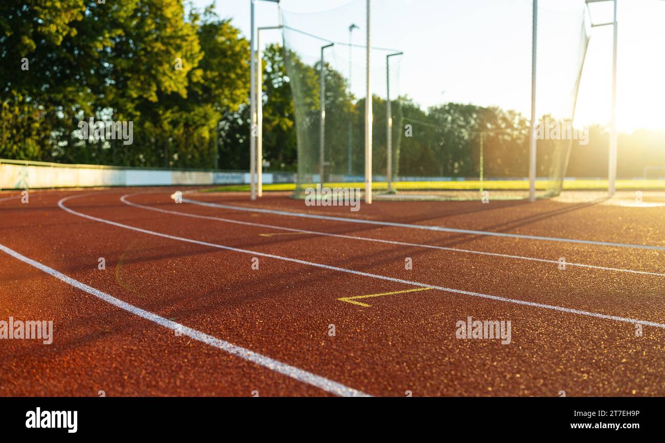 Empty running track lanes in the morning sun Stock Photo - Alamy