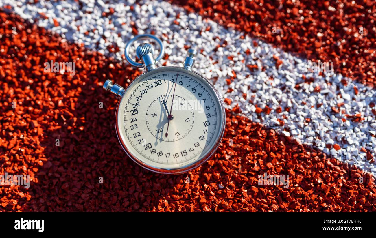 Stopwatch on red running track, white lane marker, time measurement ...