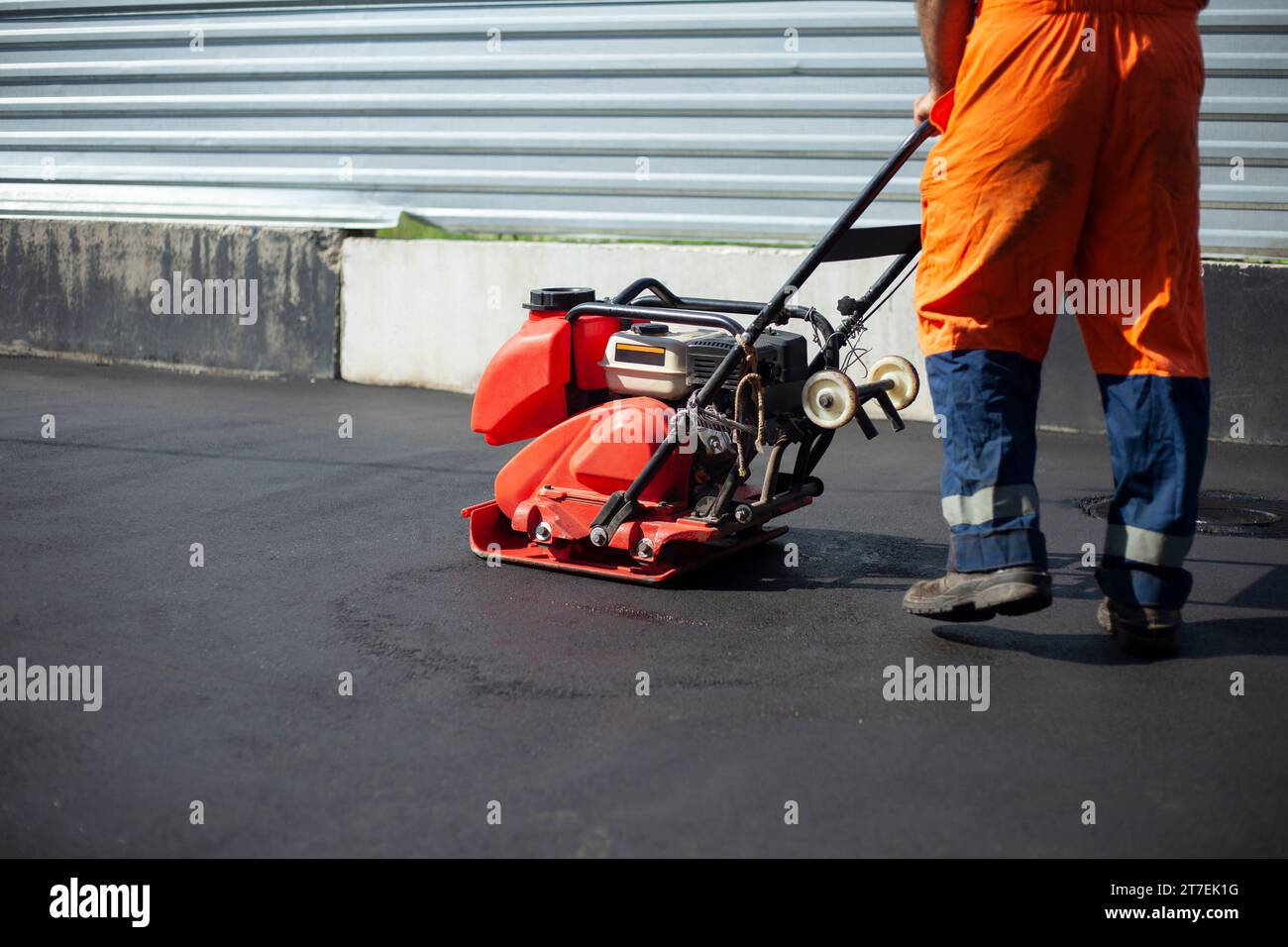 Asphalt paving machine. Worker compacts roadway. Repair of road. Diesel ...