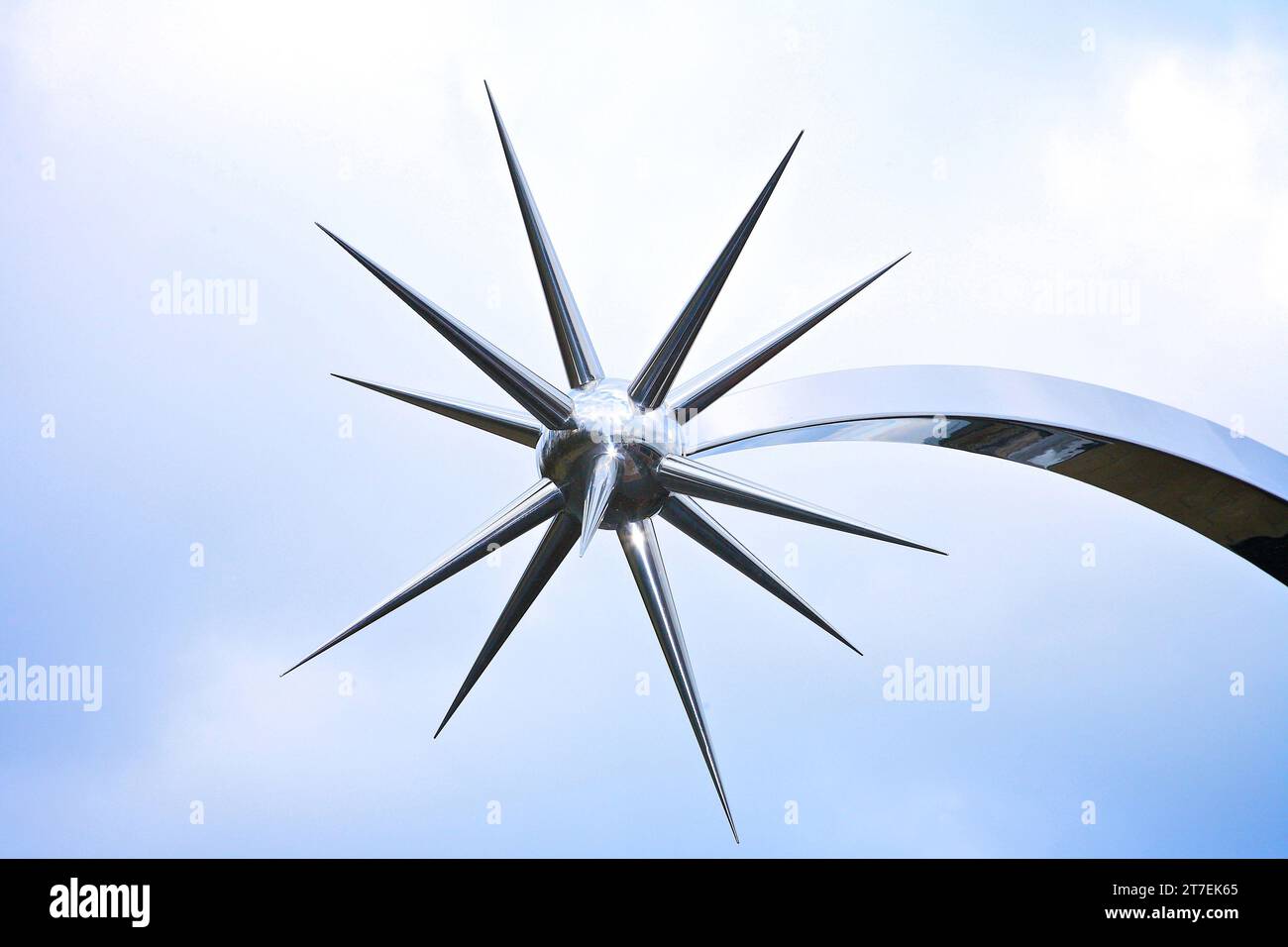 metallic silver coloured spiked sculpture with blue sky background ...