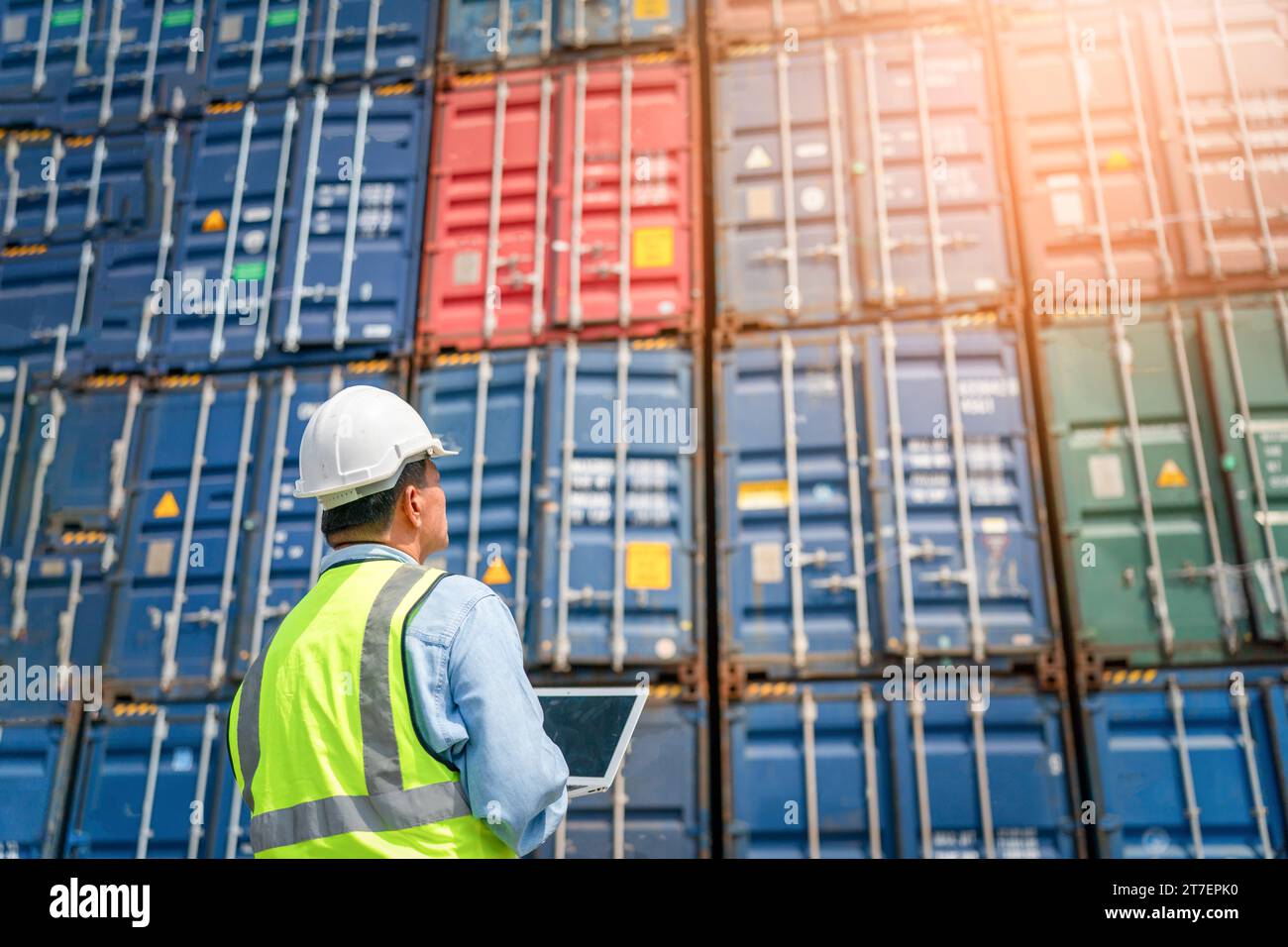 Engineer wears PPE checking container storage with cargo container ...
