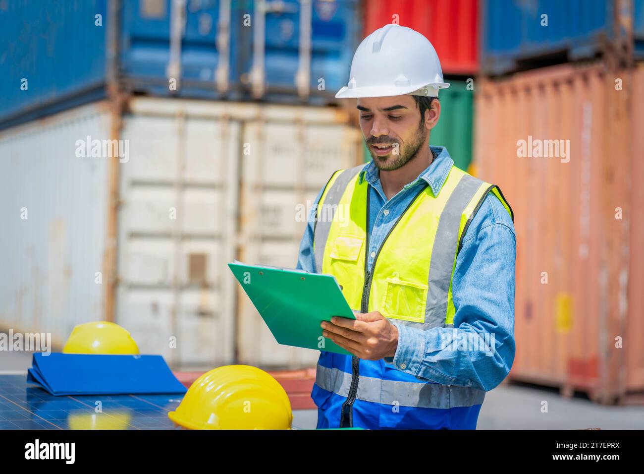 Engineer wears PPE checking container storage with cargo container ...