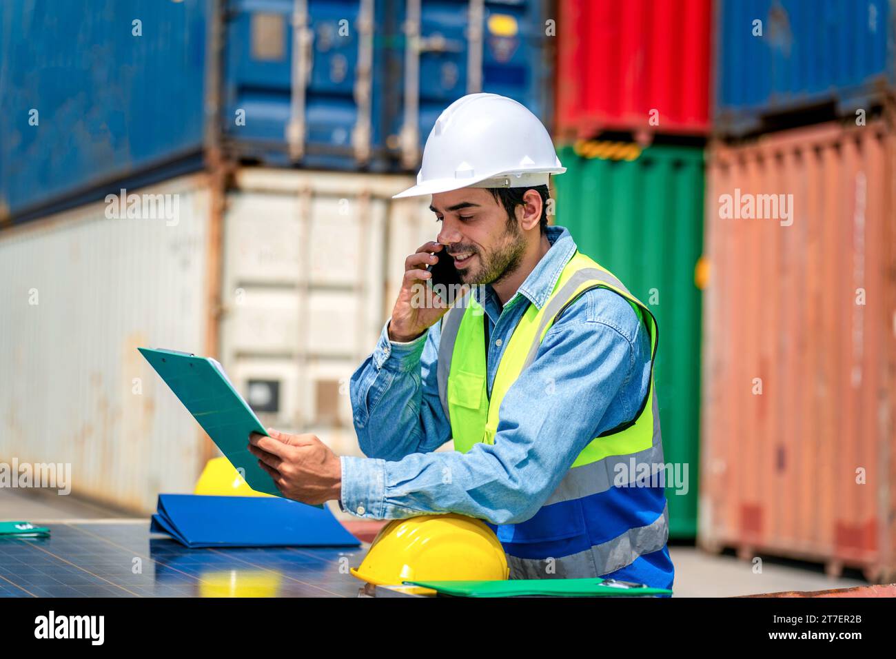 Engineer wears PPE checking container storage with cargo container ...