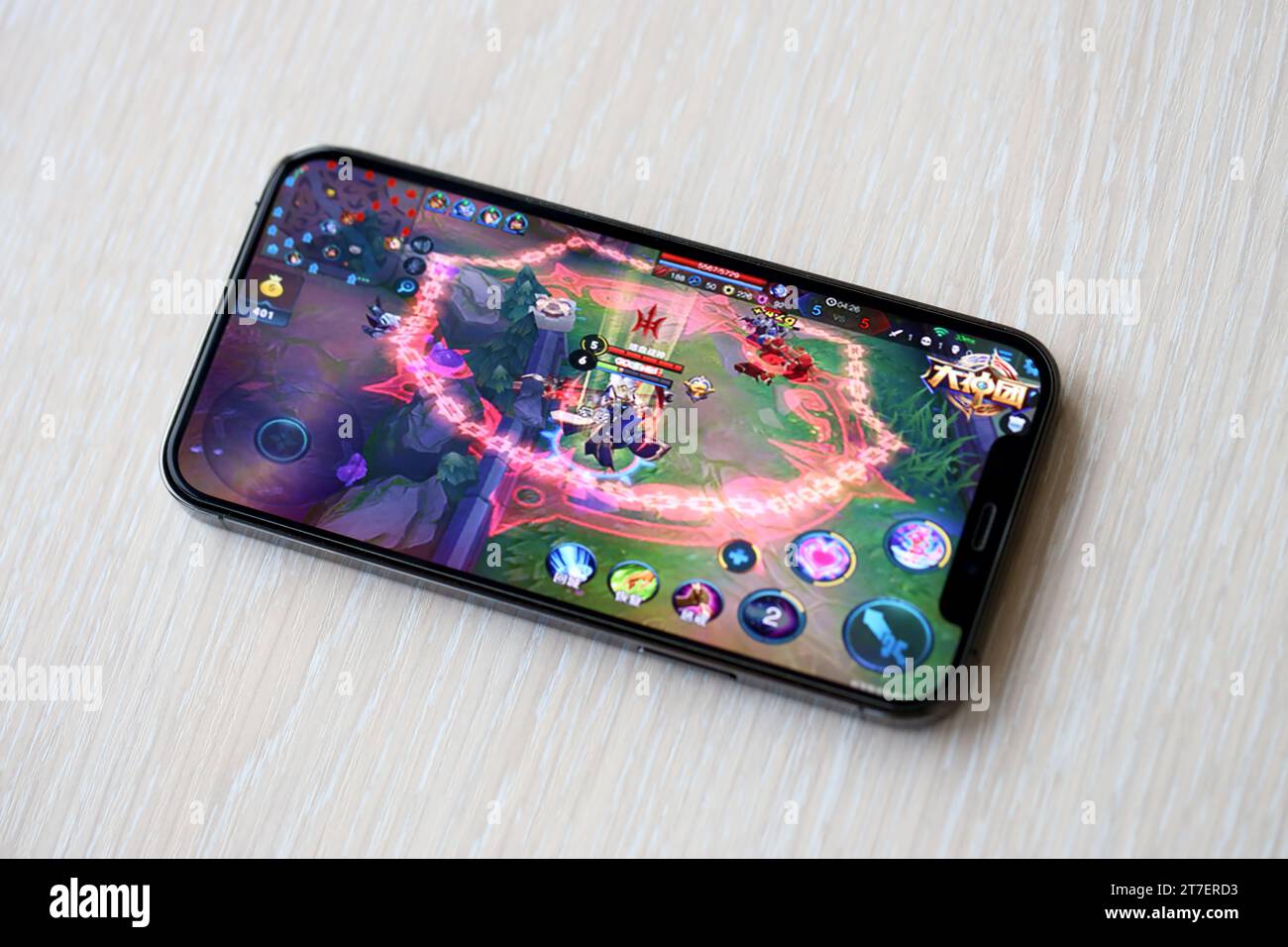 Honor of Kings mobile iOS game on iPhone 15 smartphone screen on wooden ...