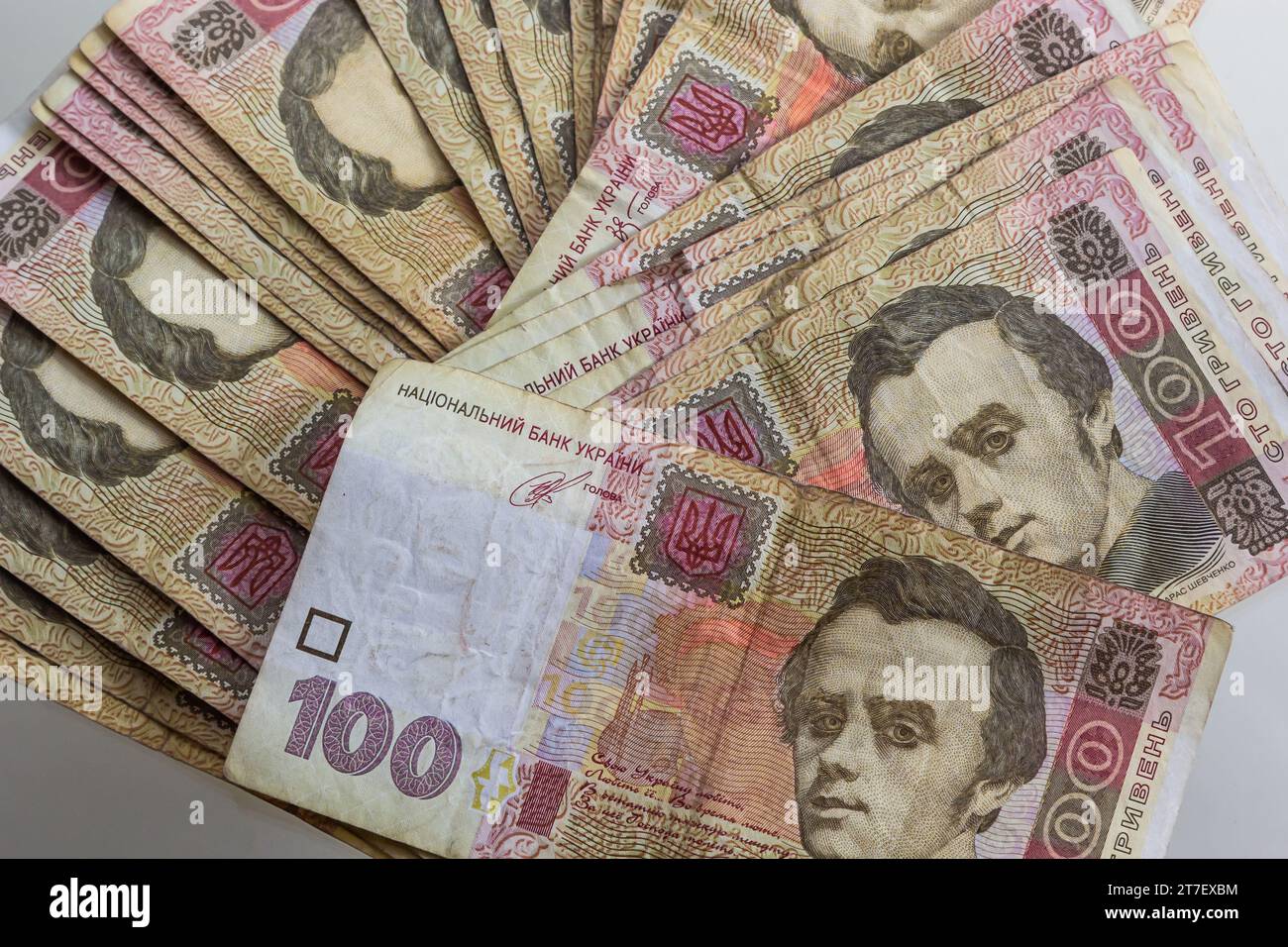 Ukrainian paper money is laid out on a blue background. 100 hryvnia ...