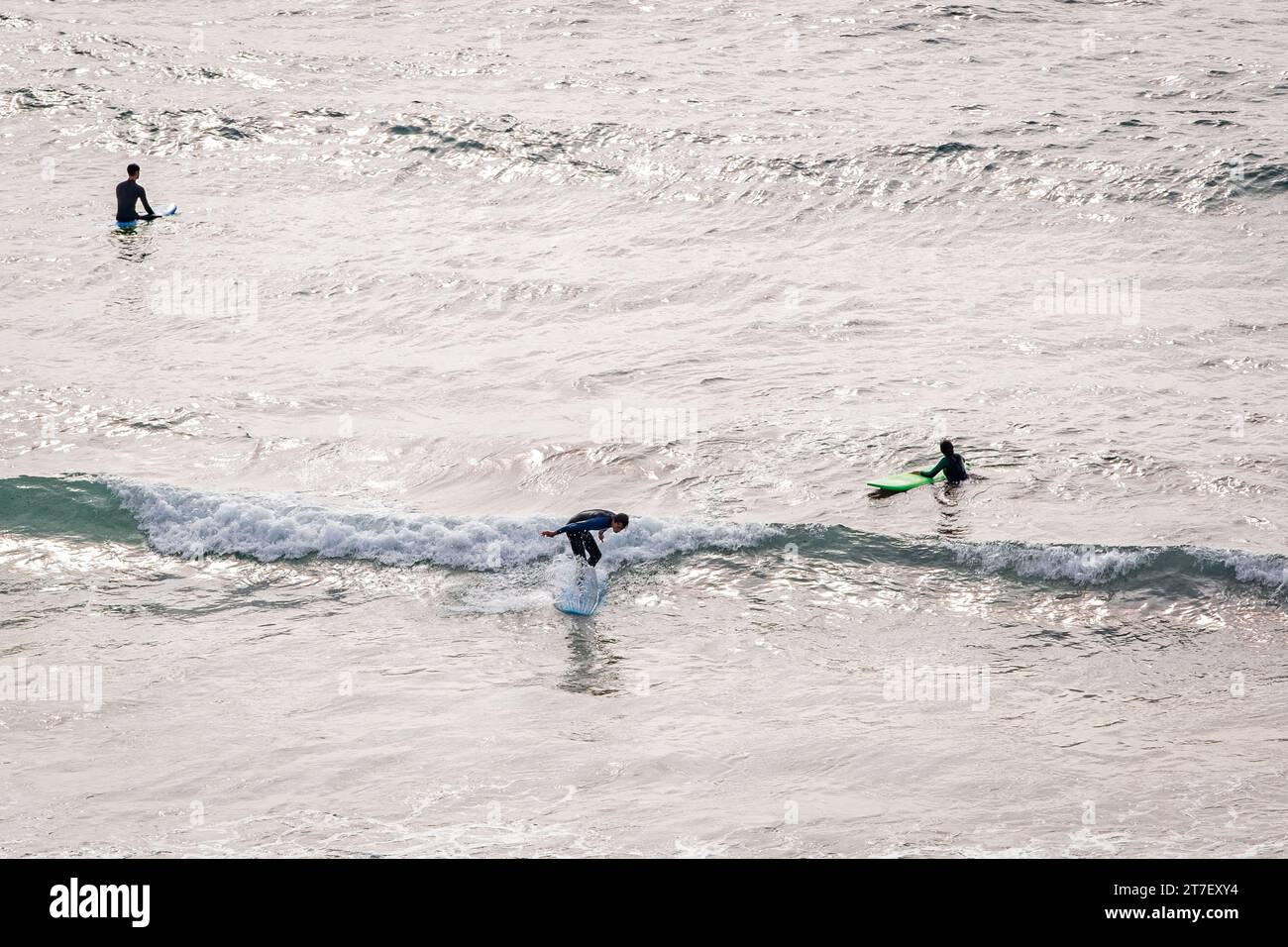 Coastal Harmony: Aerial View of Three Surfers Creating a Triangular ...