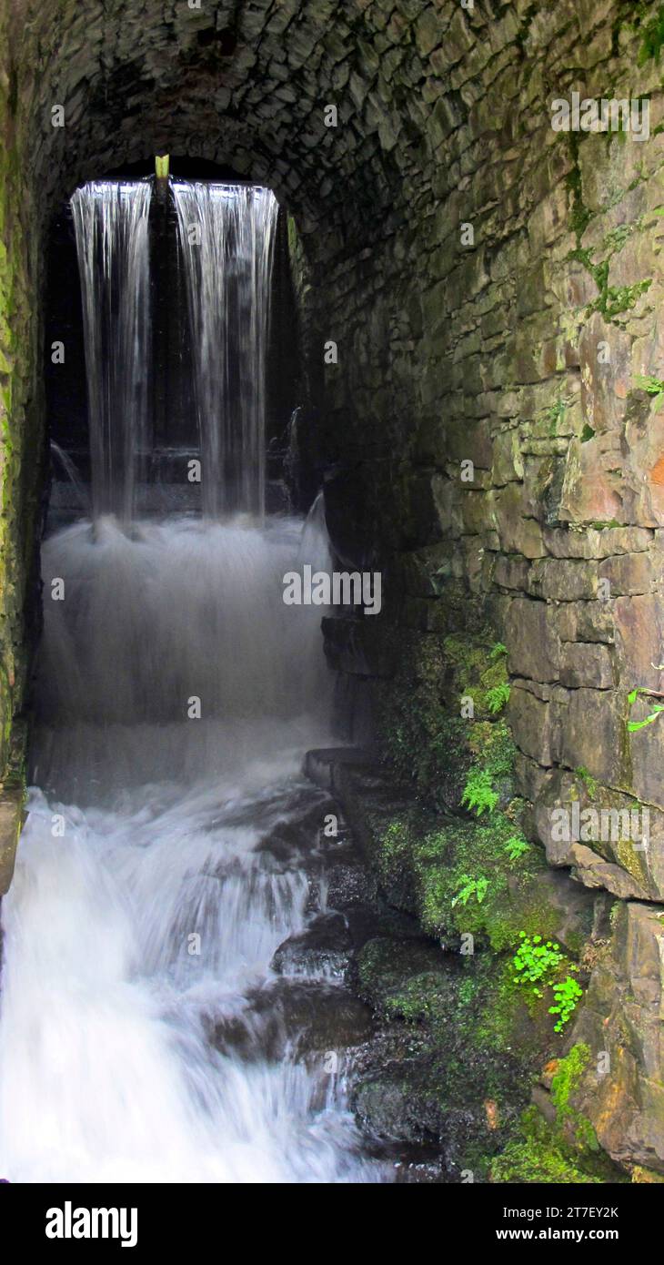 underground tunnel with water from a waterfall flowing over the rocks ...