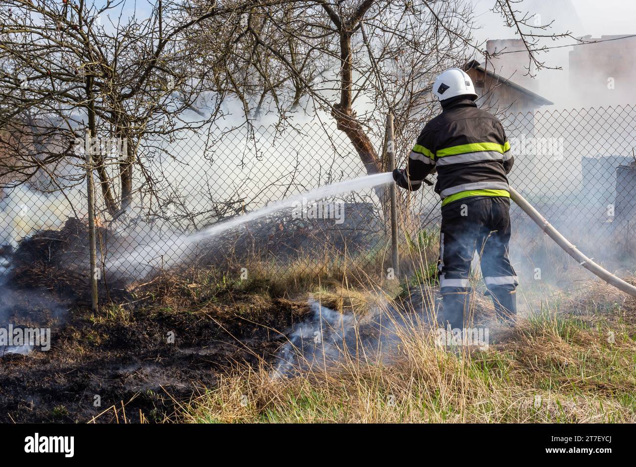 spring fire, burning dry grass near buildings in the countryside ...