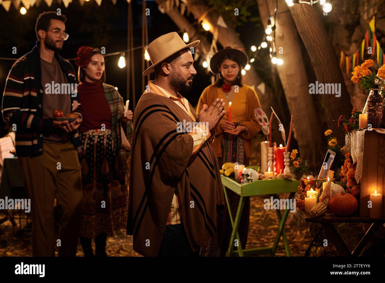 Man in traditional clothes praying at altar outdoors and celebrating ...