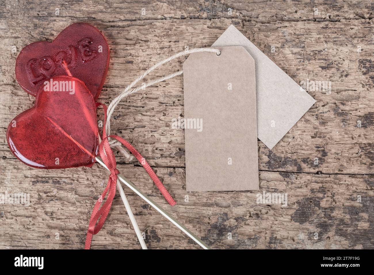 heart shaped red candies on wooden table with name tags Stock Photo - Alamy