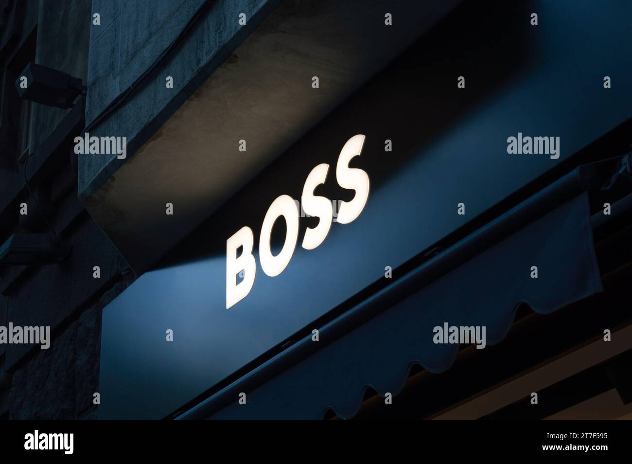 Boss brand retail store black signboard with lit logo at night. Tbilisi ...
