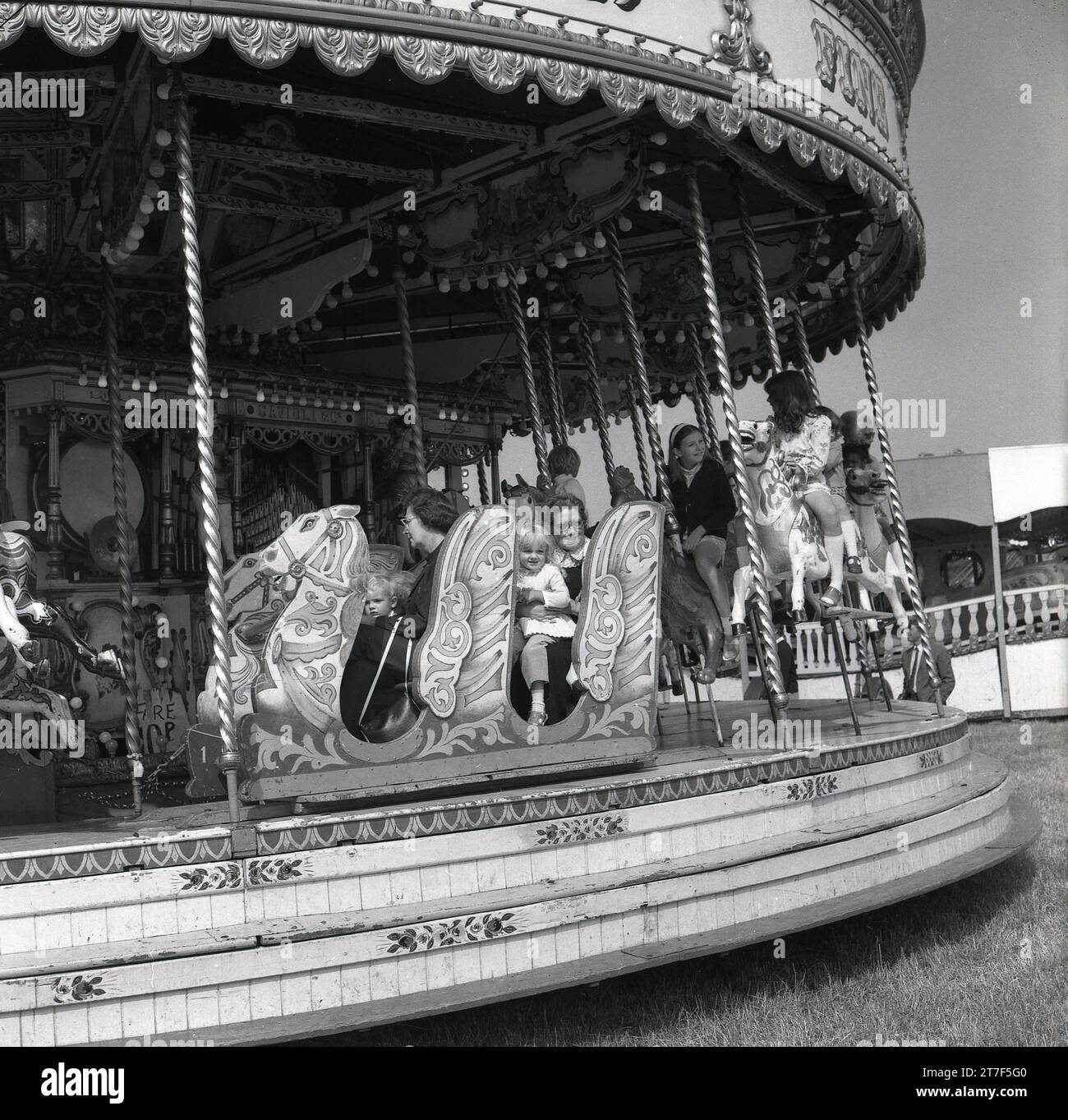 1970s, historical, adults and children riding on a merry-go-round or ...