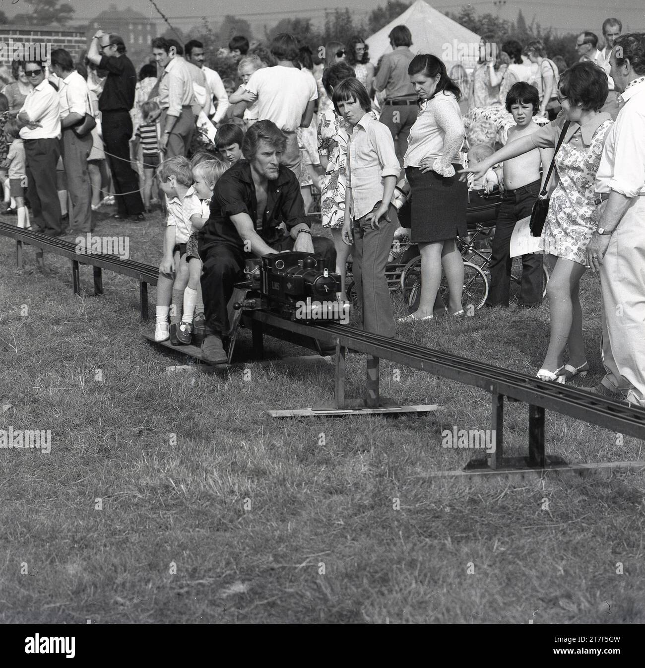 1970s, historical, outside at a fete some young children having a ride ...
