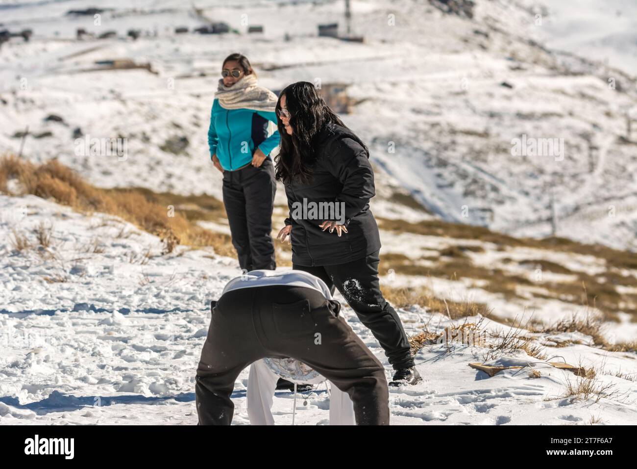 three young latin people playing in the snow in the mountains of sierra ...