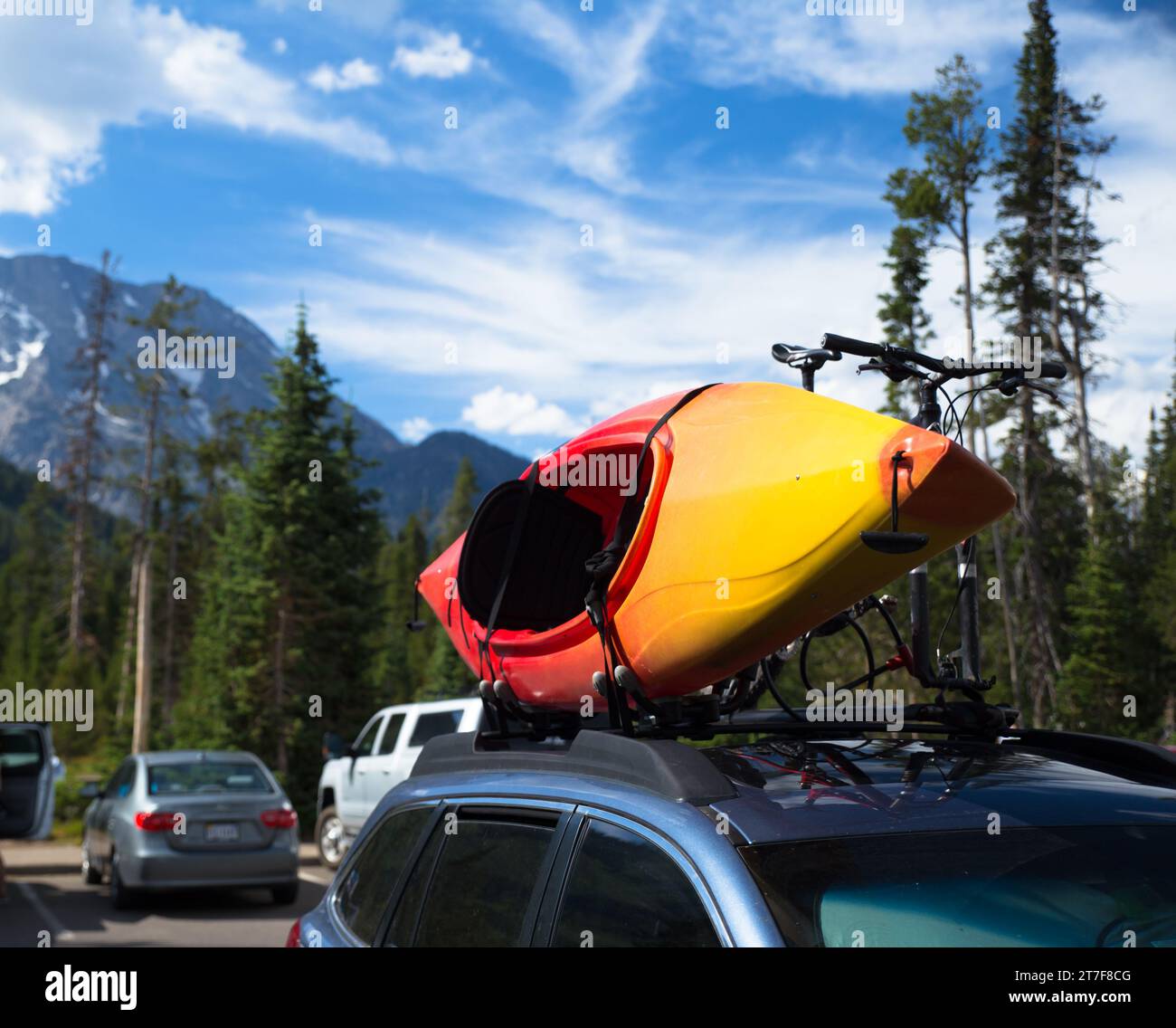 an orange kayak tied on the top of a car for vacation Stock Photo - Alamy