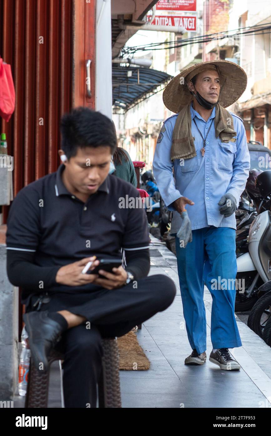 street scene in Bali, Indonesia, sith smartphone and traditional hat ...