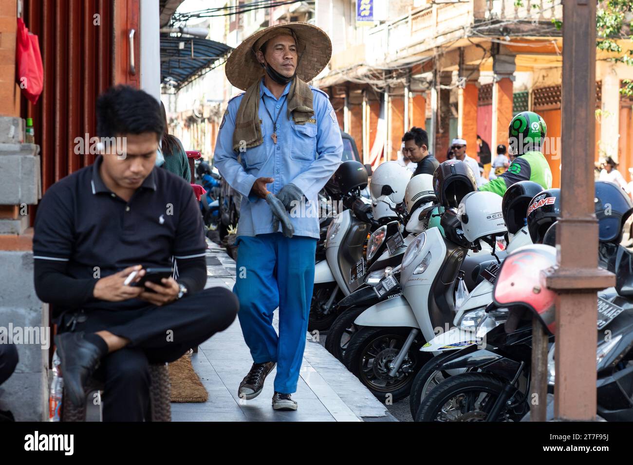 street scene in Bali, Indonesia, sith smartphone and traditional hat ...