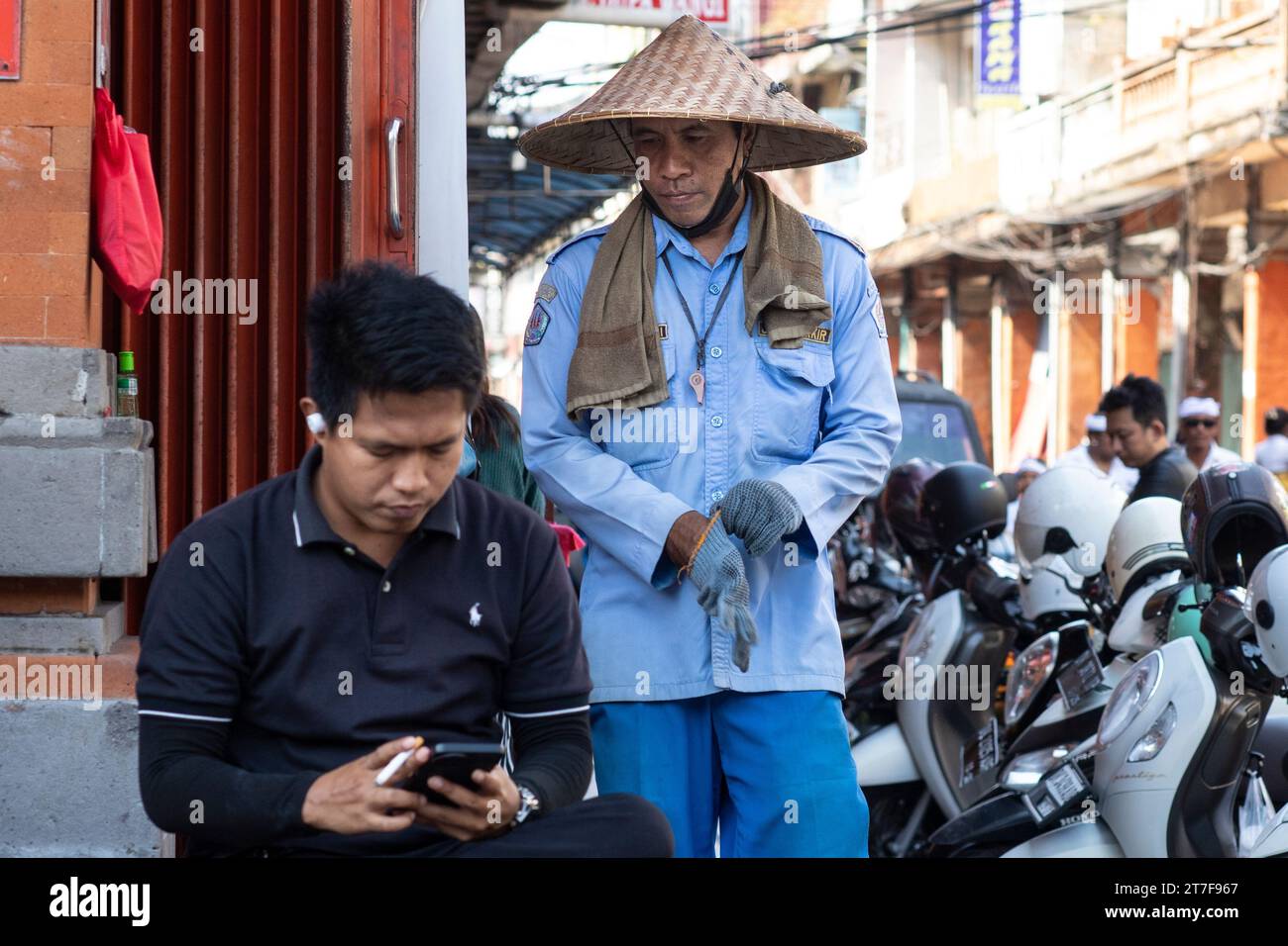 street scene in Bali, Indonesia, sith smartphone and traditional hat ...