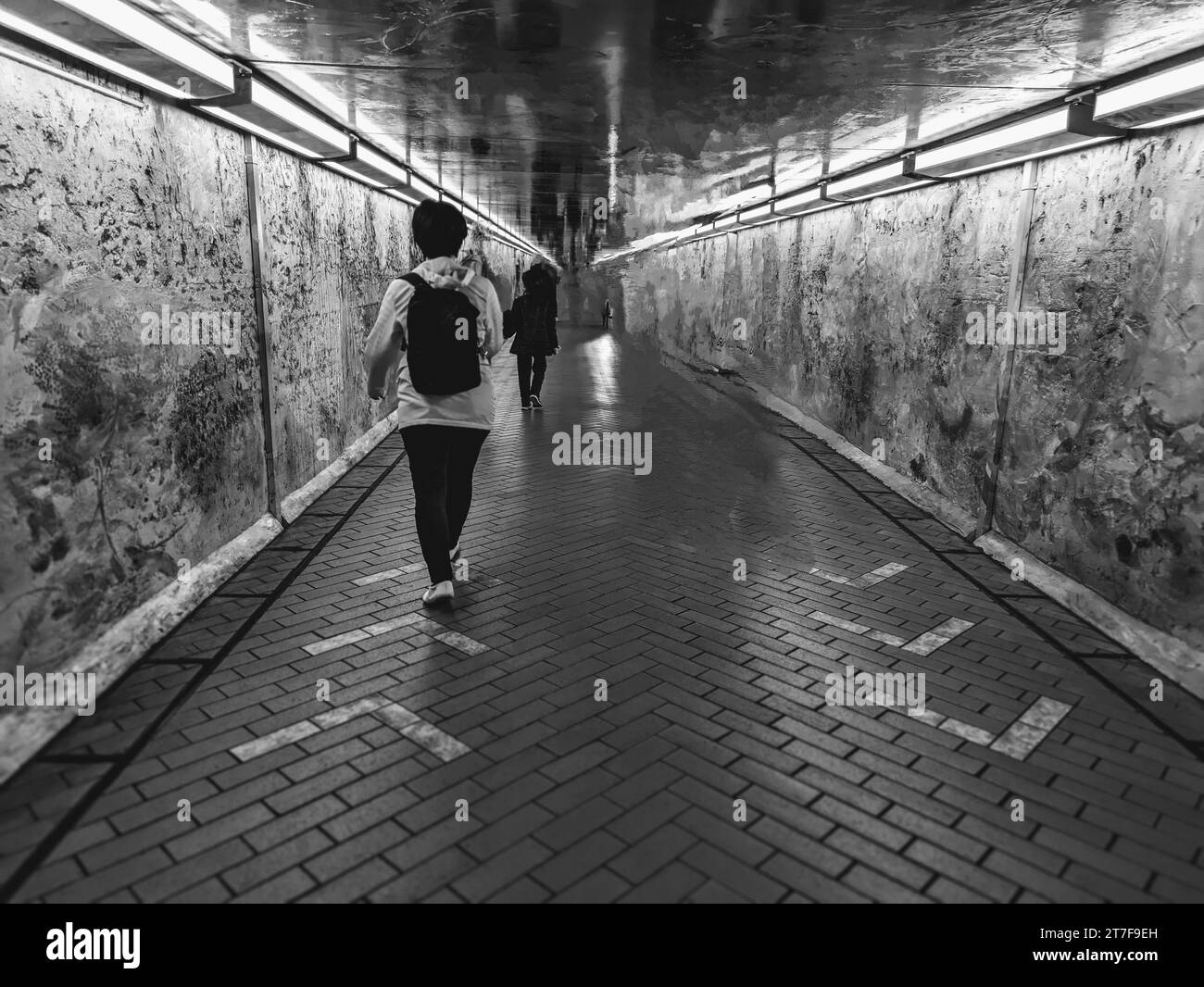 A figure stands in silhouette against a backdrop of illuminated brick ... A figure stands in silhouette against a backdrop of illuminated brick ...