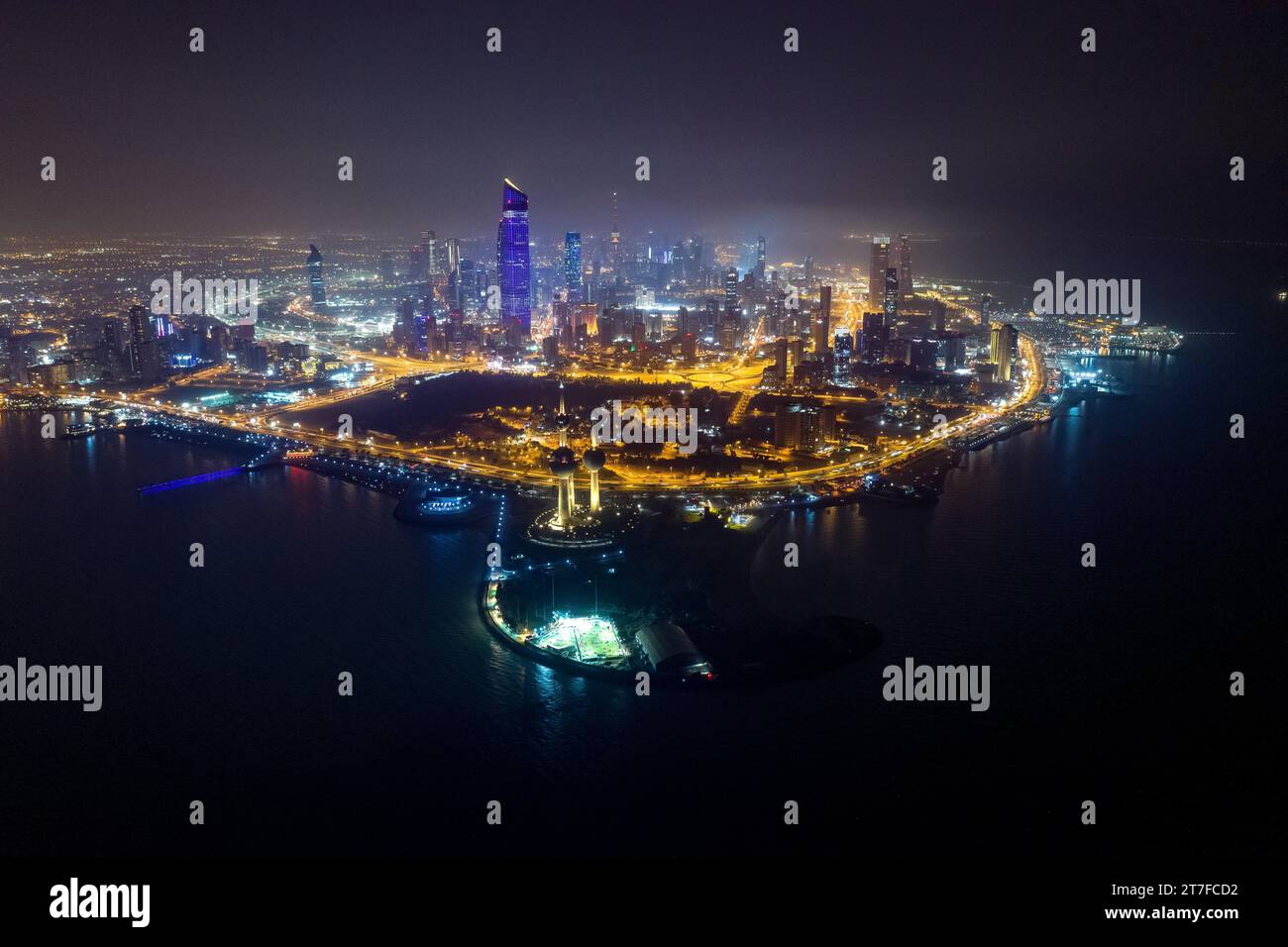 A nighttime view of a bustling city skyline, illuminated by the lights ...