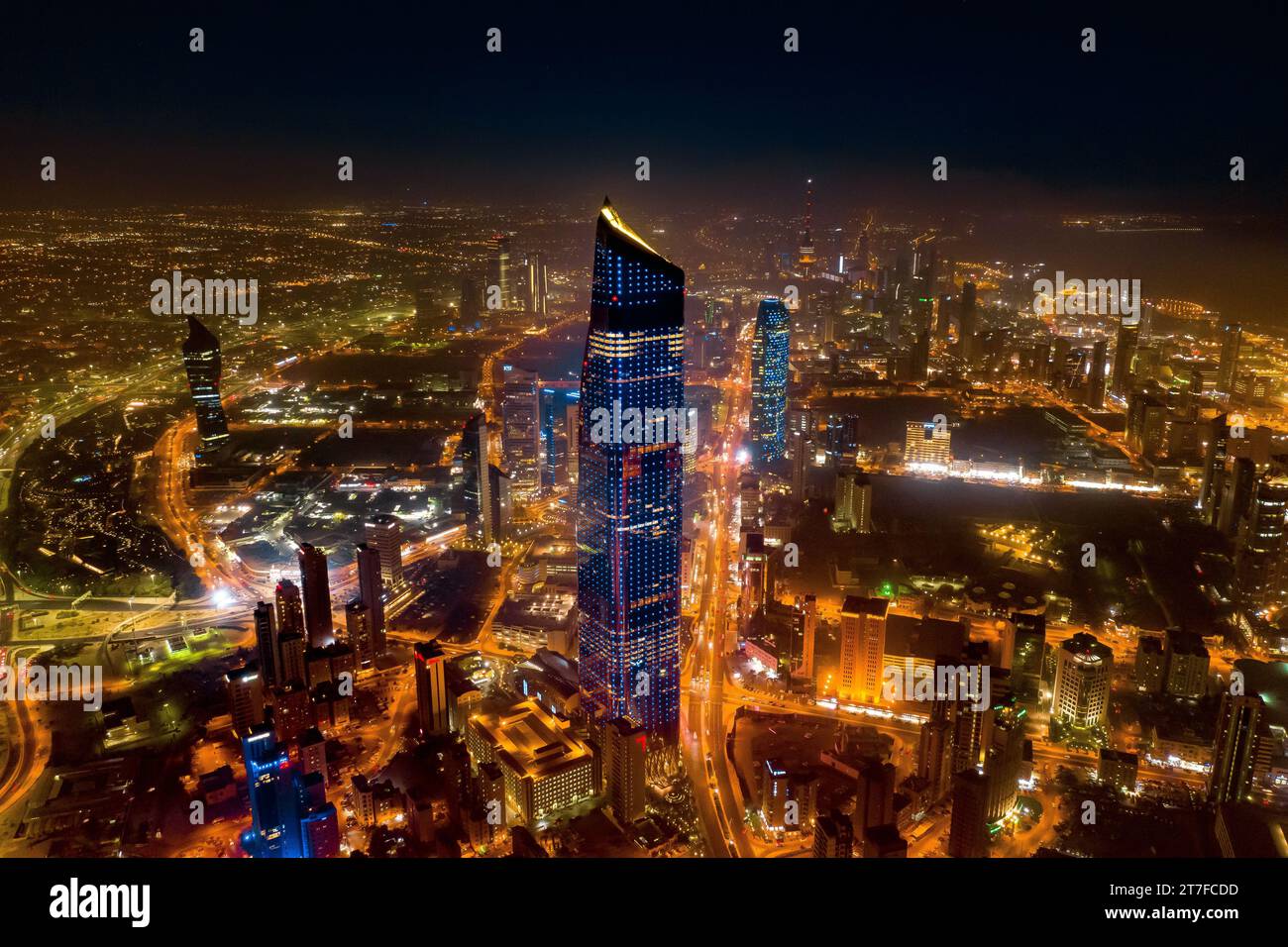 A nighttime view of a bustling city skyline, illuminated by the lights ...