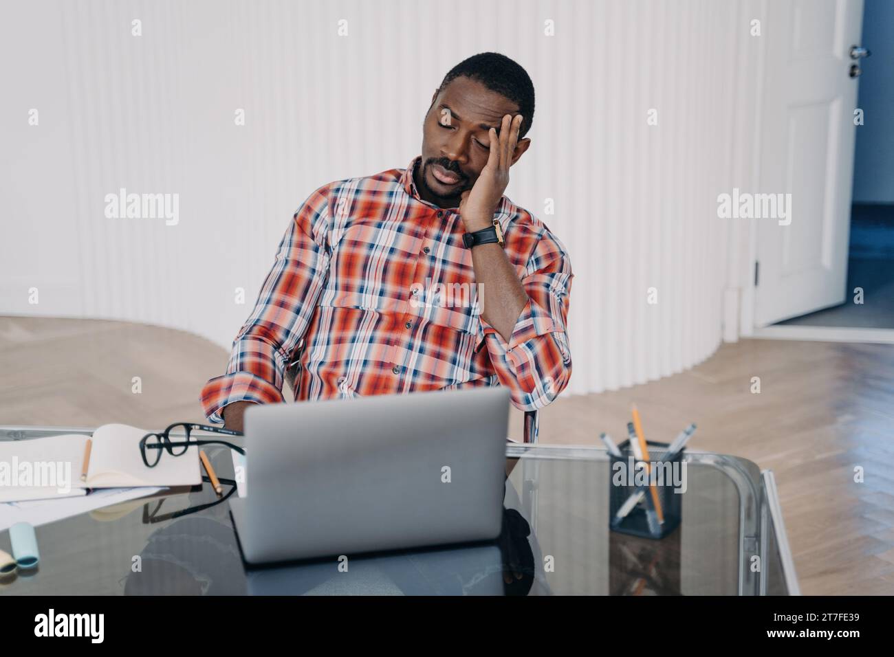 Stressed Black man at desk with laptop, feeling overwhelmed with work ...