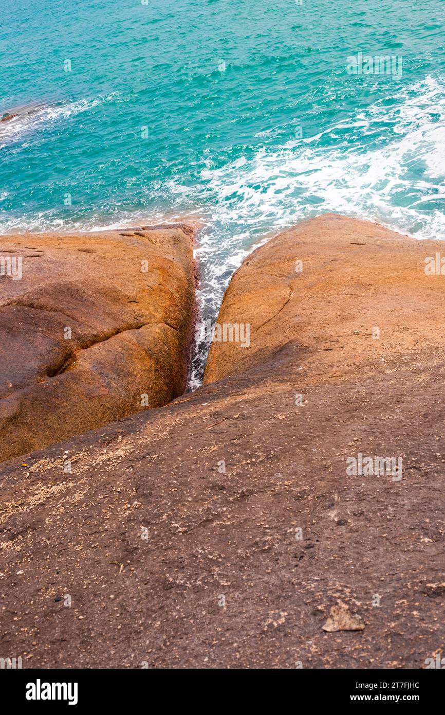 Vertical seascape. A stone mountain with a crevice goes into the sea ...