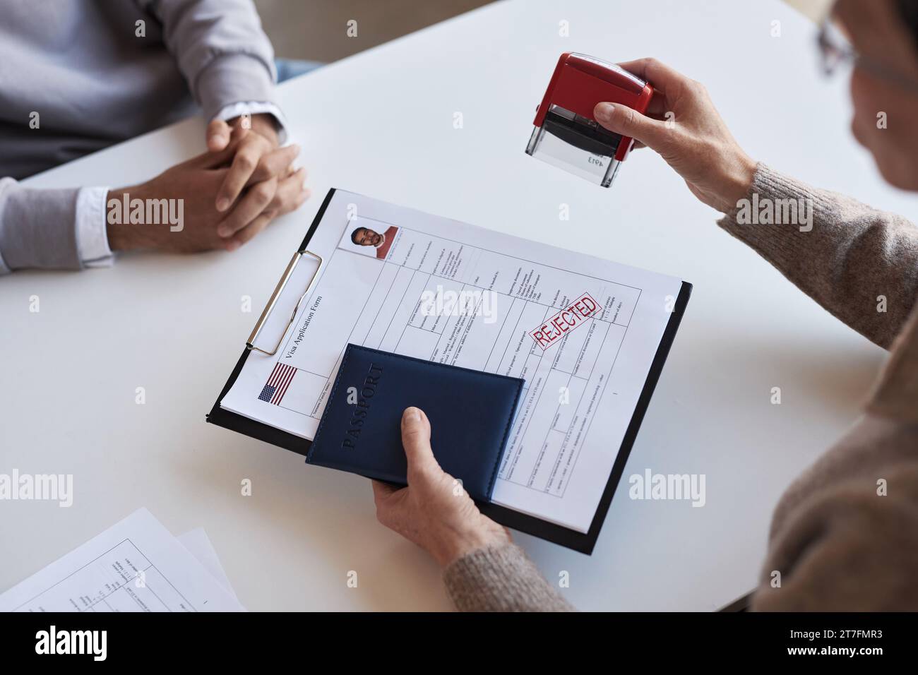 Close-up of mature female manager putting rejection stamp on filled ...