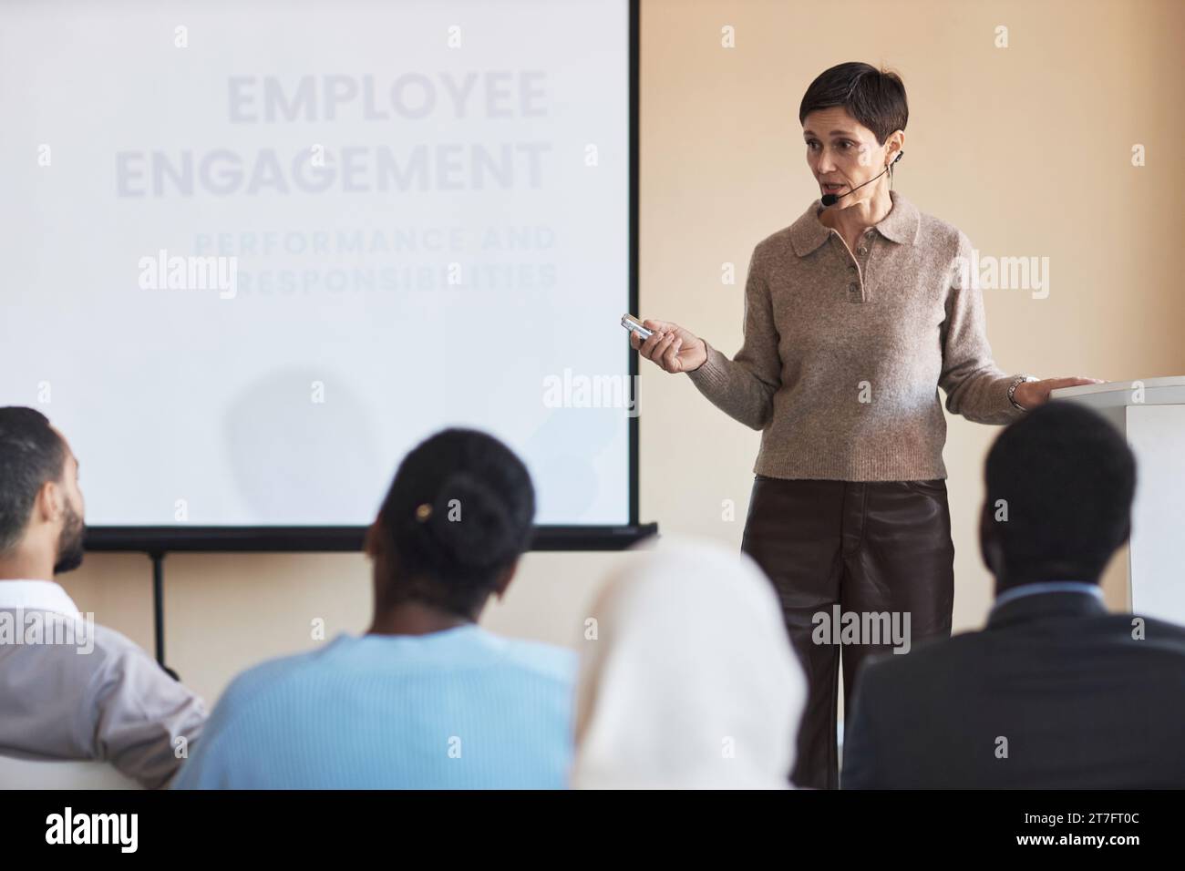 Confident mature female speaker standing by whiteboard during ...
