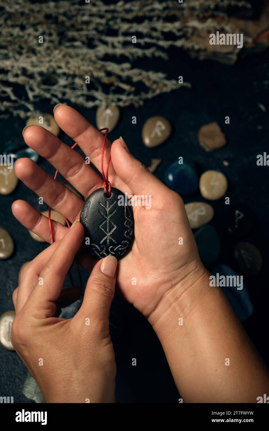 stone runic talisman for good luck in your hand Stock Photo - Alamy