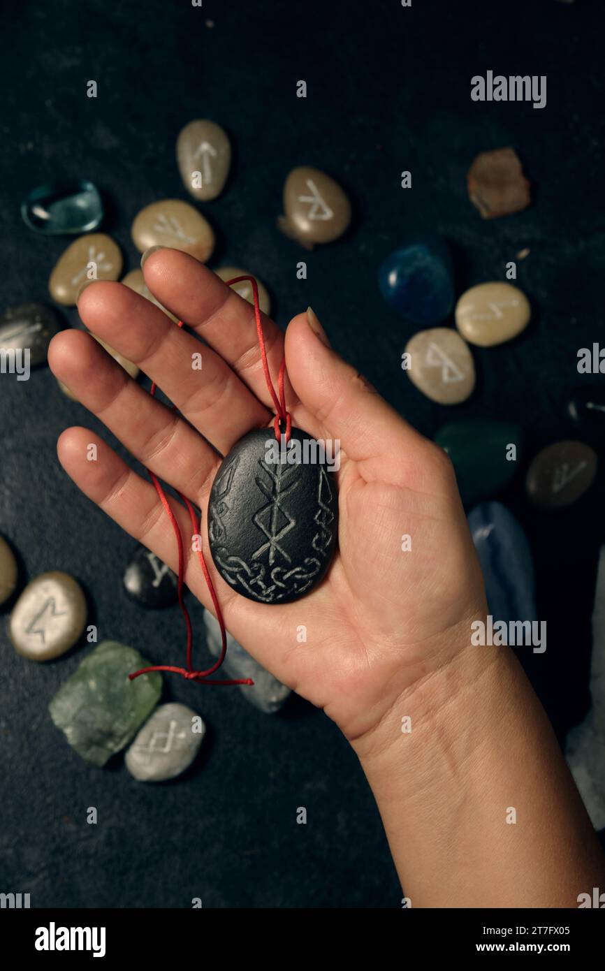 stone runic talisman for good luck in your hand Stock Photo - Alamy