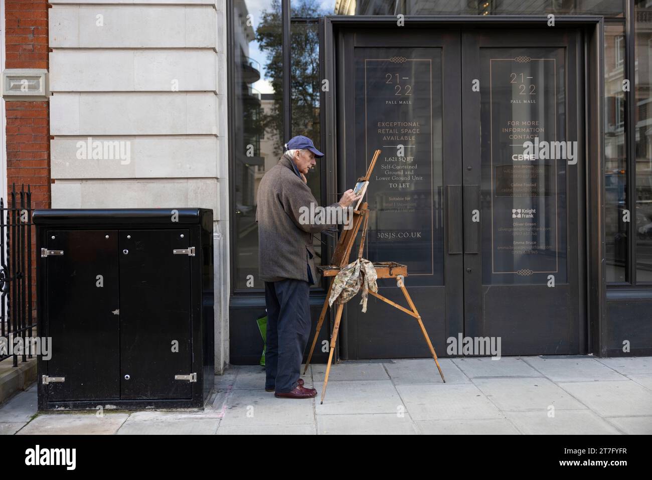 An artist with his easel positioned along Pall Mall whilst he paints a ...