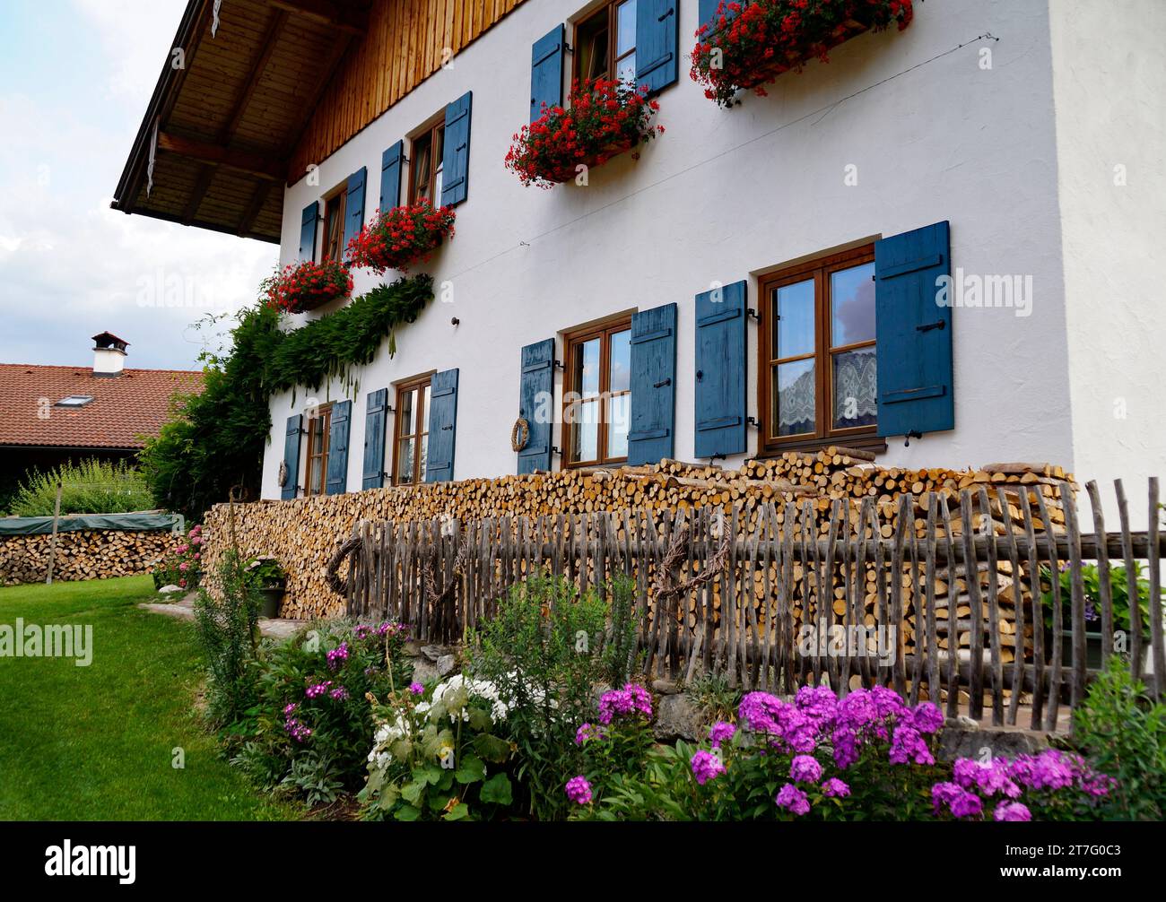 idyllic scene with a traditional Bavarian rustic alpine farmhouse with ...