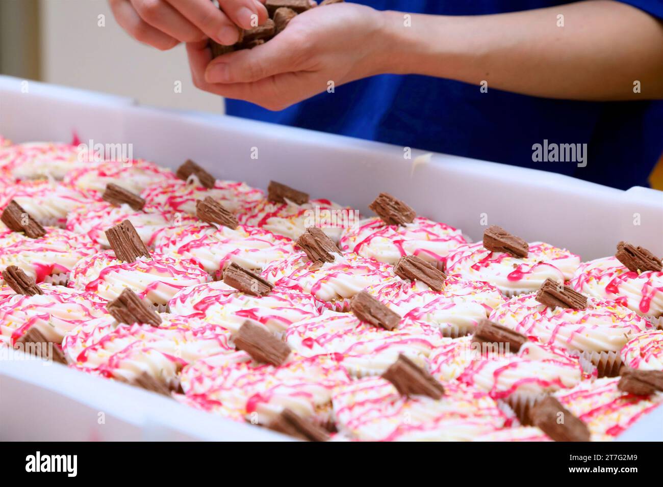 selection of cream cakes with raspberry topping and a chocolate flake ...