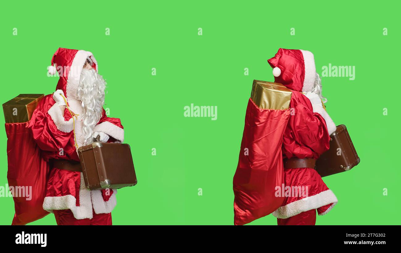 Joyful adult disguised in santa suit holding suitcase and waiting for ...