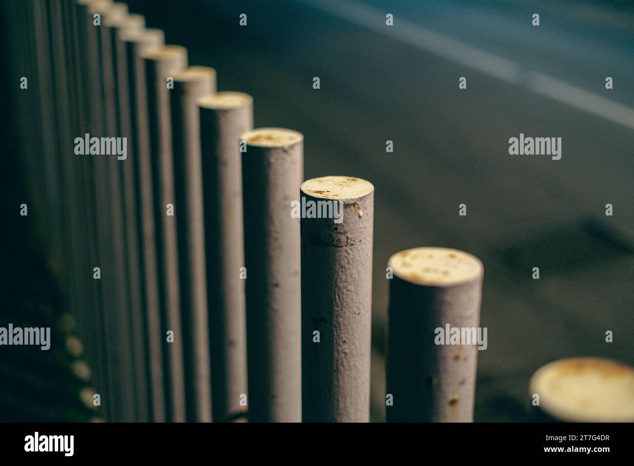 Row of white piles that divide the sidewalk from the road where cars ...