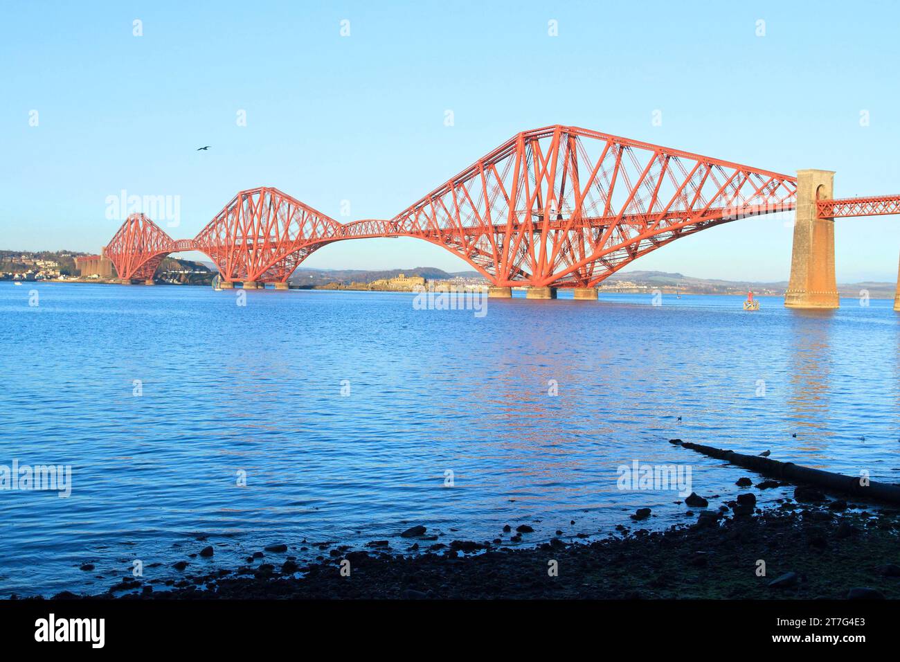 full view of forth road railway bridge with the river below, blue sky ...