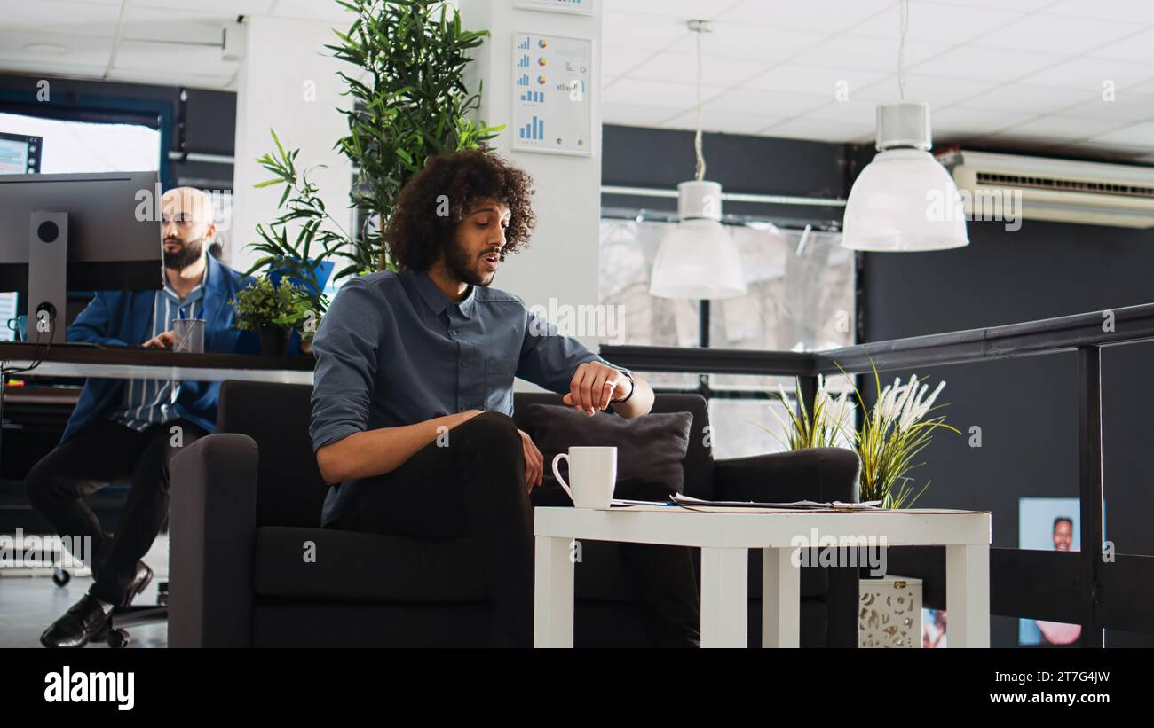 Employee using smartwatch videocall entering hi-res stock photography ...