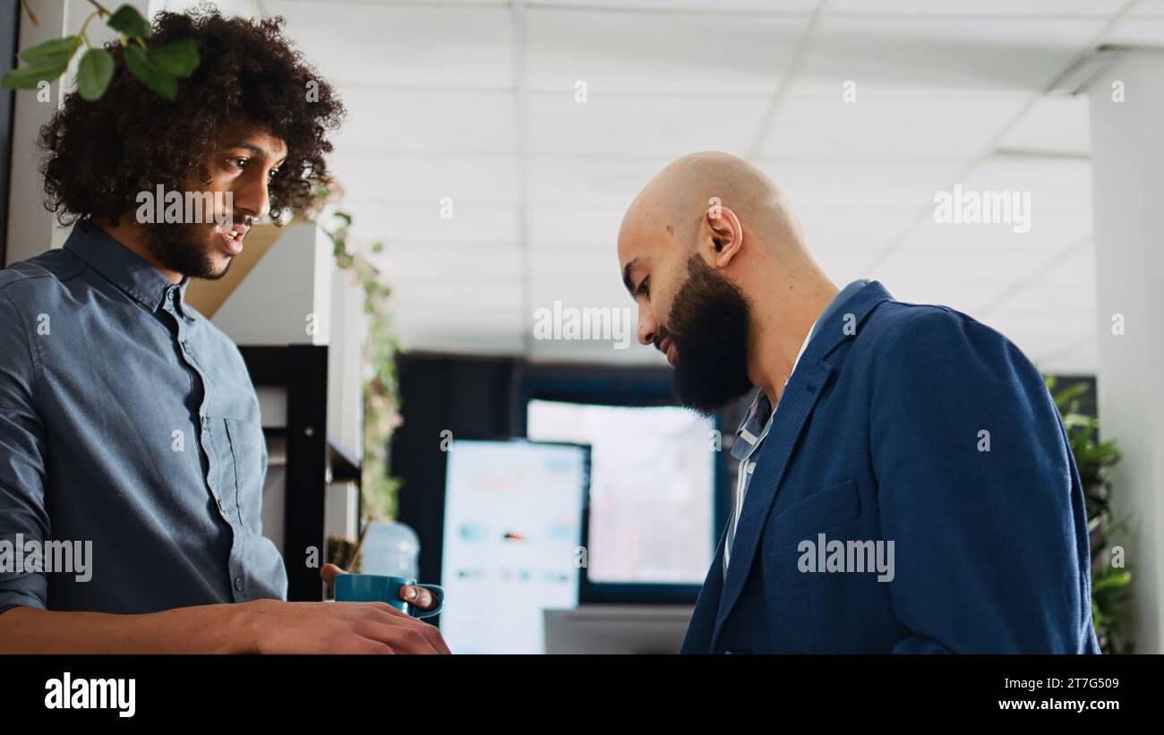 Office workers meeting on work break, laughing together and enjoying ...
