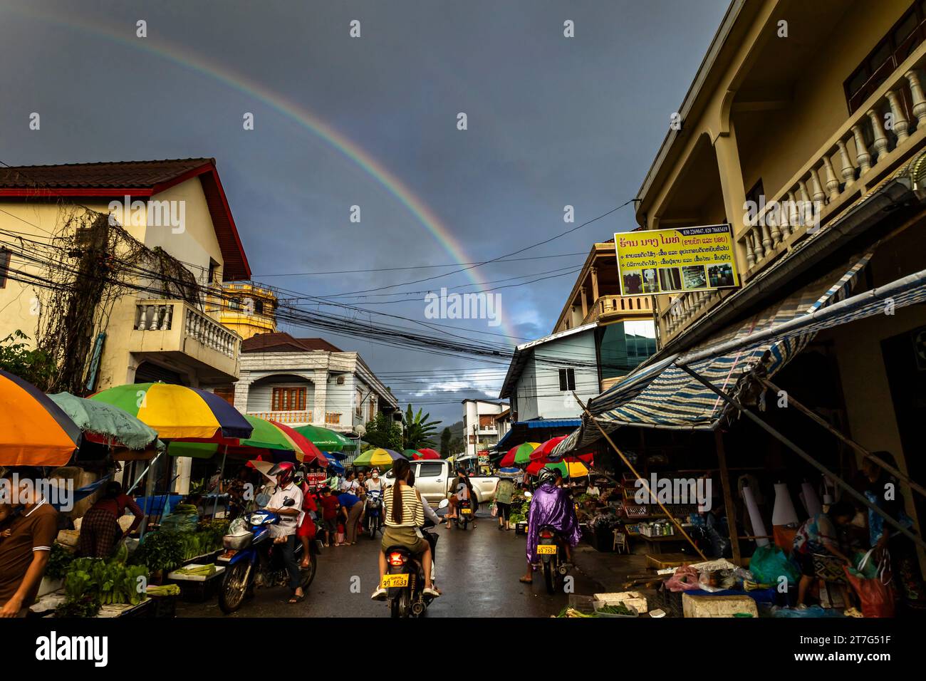 Rainbow after rain, street of central market, city center, Phonsavan ...