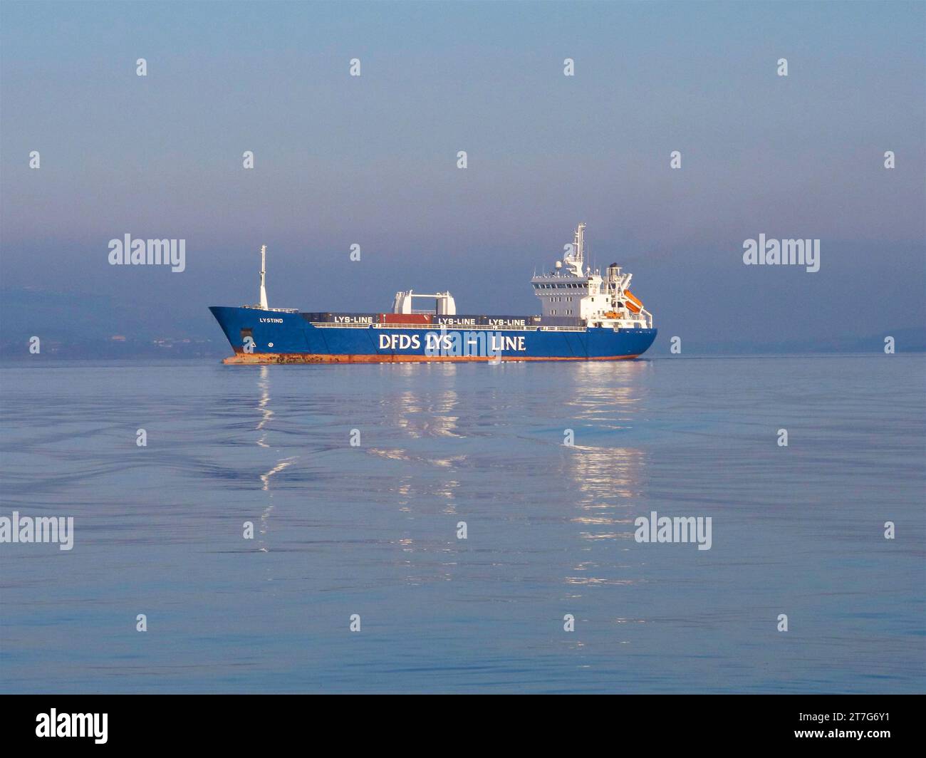 blue and white coloured cargo ship on the blue of the ocean on a cludy ...
