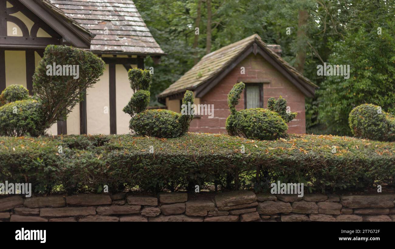 Topiary animals on the top of a yew hedge and sandstone wall ...