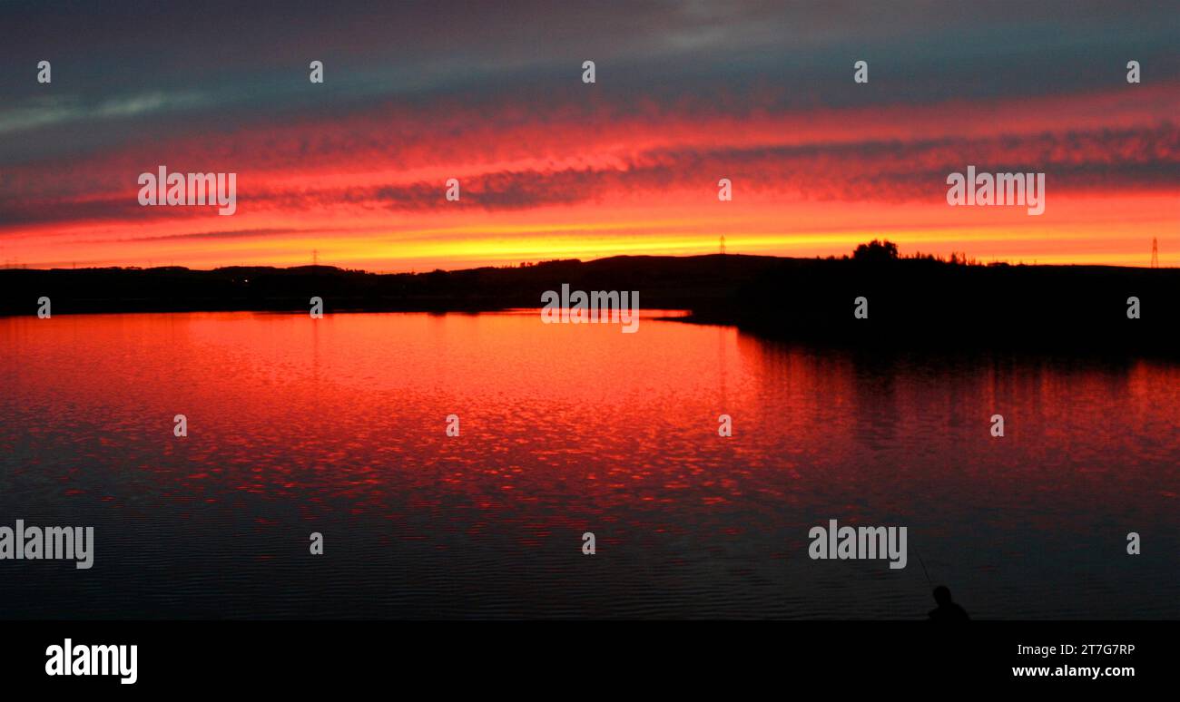 barrhead reservoir in barrhead in scotland with red and orange sky as ...