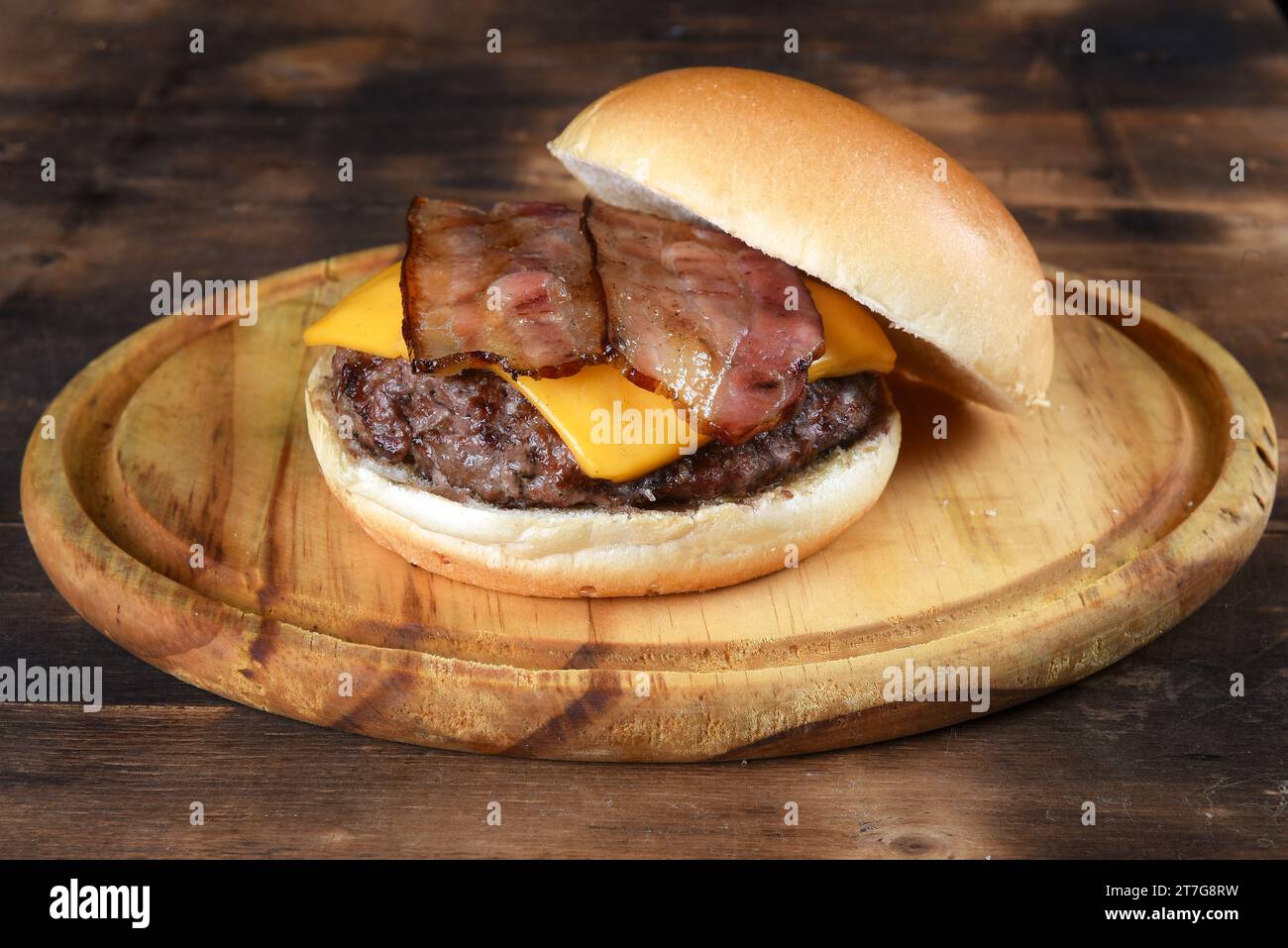 sandwich bread cut in half with meat and cheese burger and bacon on top ...