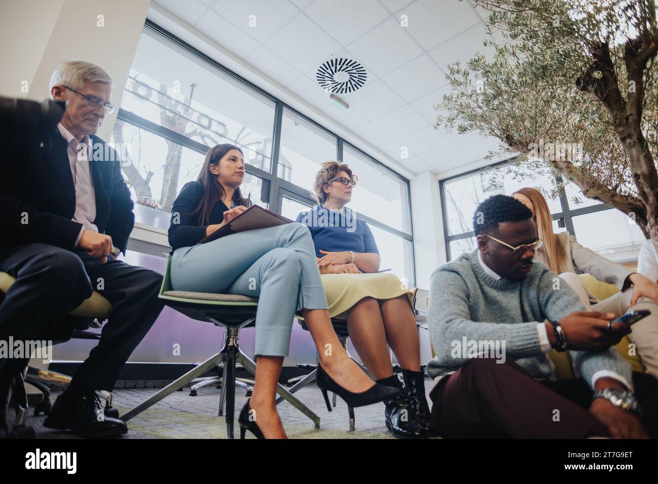 Multigenerational colleagues in a modern office engage in productive brainstorming sessions ...