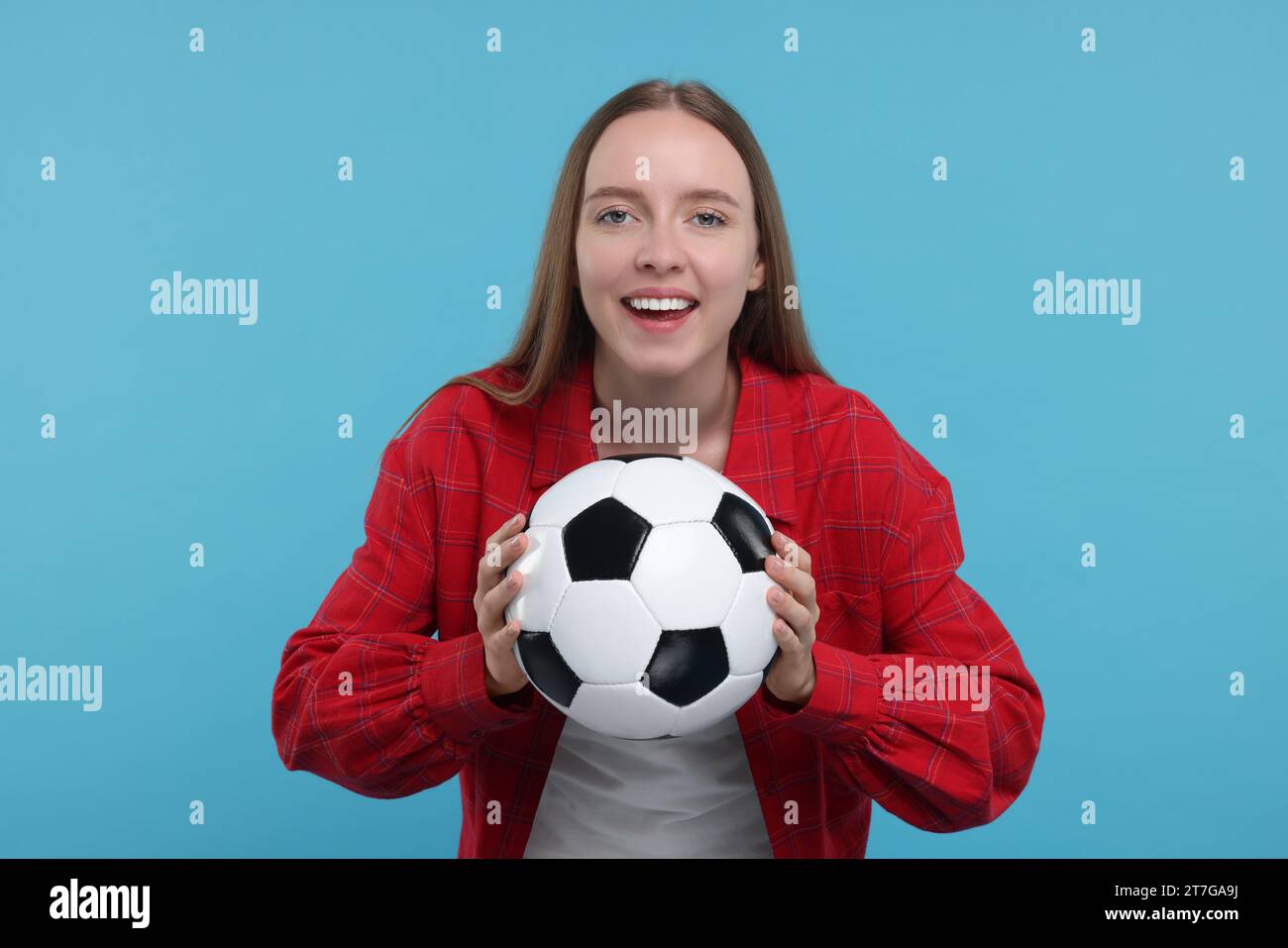 Emotional sports fan with ball on light blue background Stock Photo - Alamy