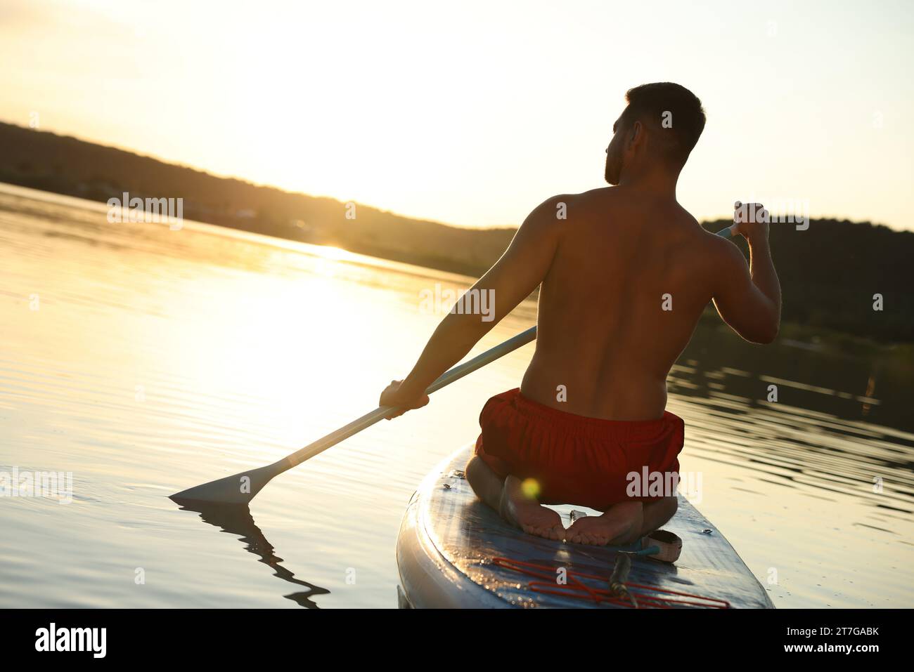 Man paddle boarding on SUP board in river at sunset, back view Stock ...
