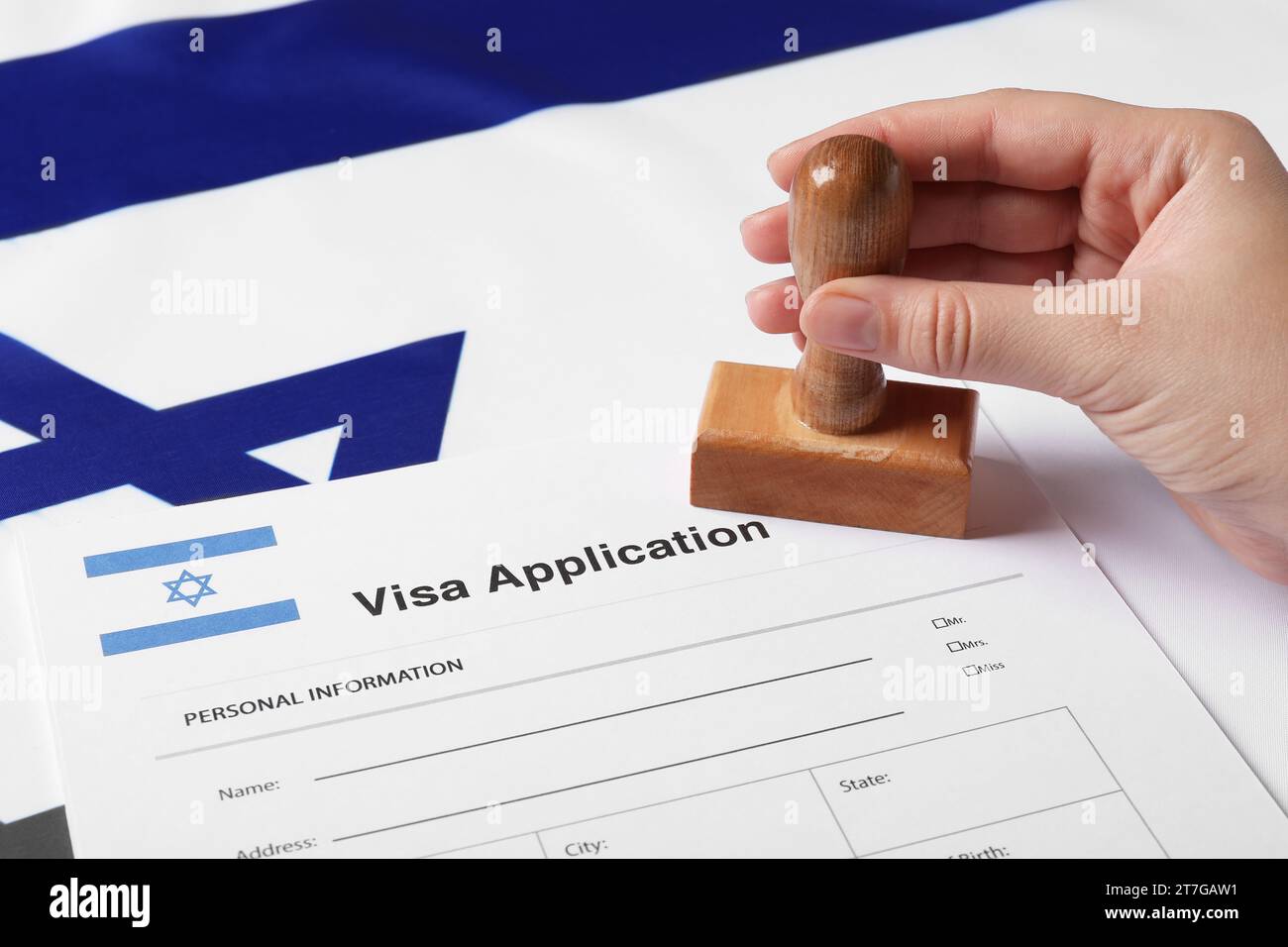 Immigration to Israel. Woman stamping visa application form on flag ...