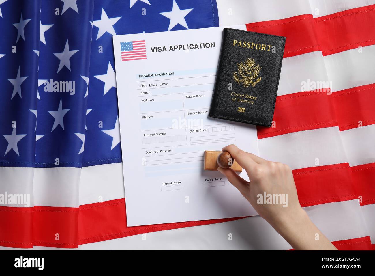 Immigration to USA. Woman stamping visa application form on flag, top ...